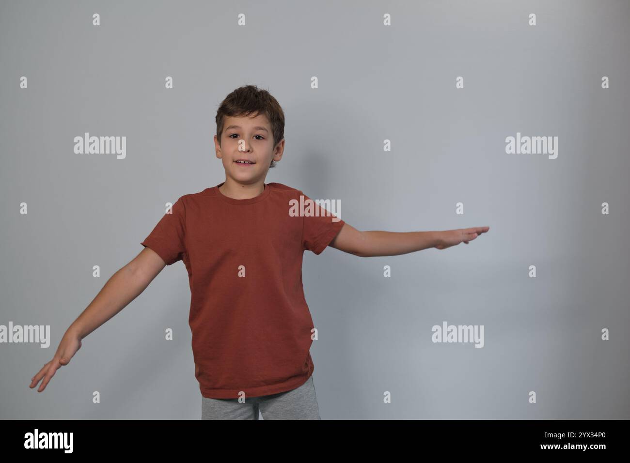 The child's slanted stance and smile radiate playful energy. It ...