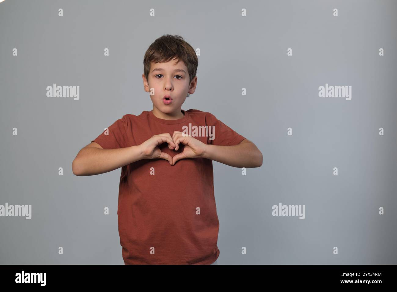 Child shows a heart sign, cheerful and loving. Captures the open ...
