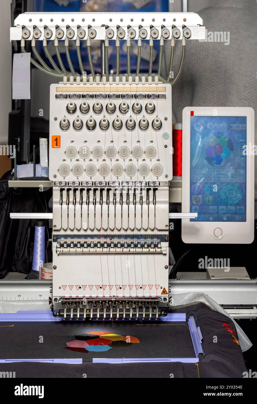 Intricate embroidery machine in action creating colorful designs in a ...