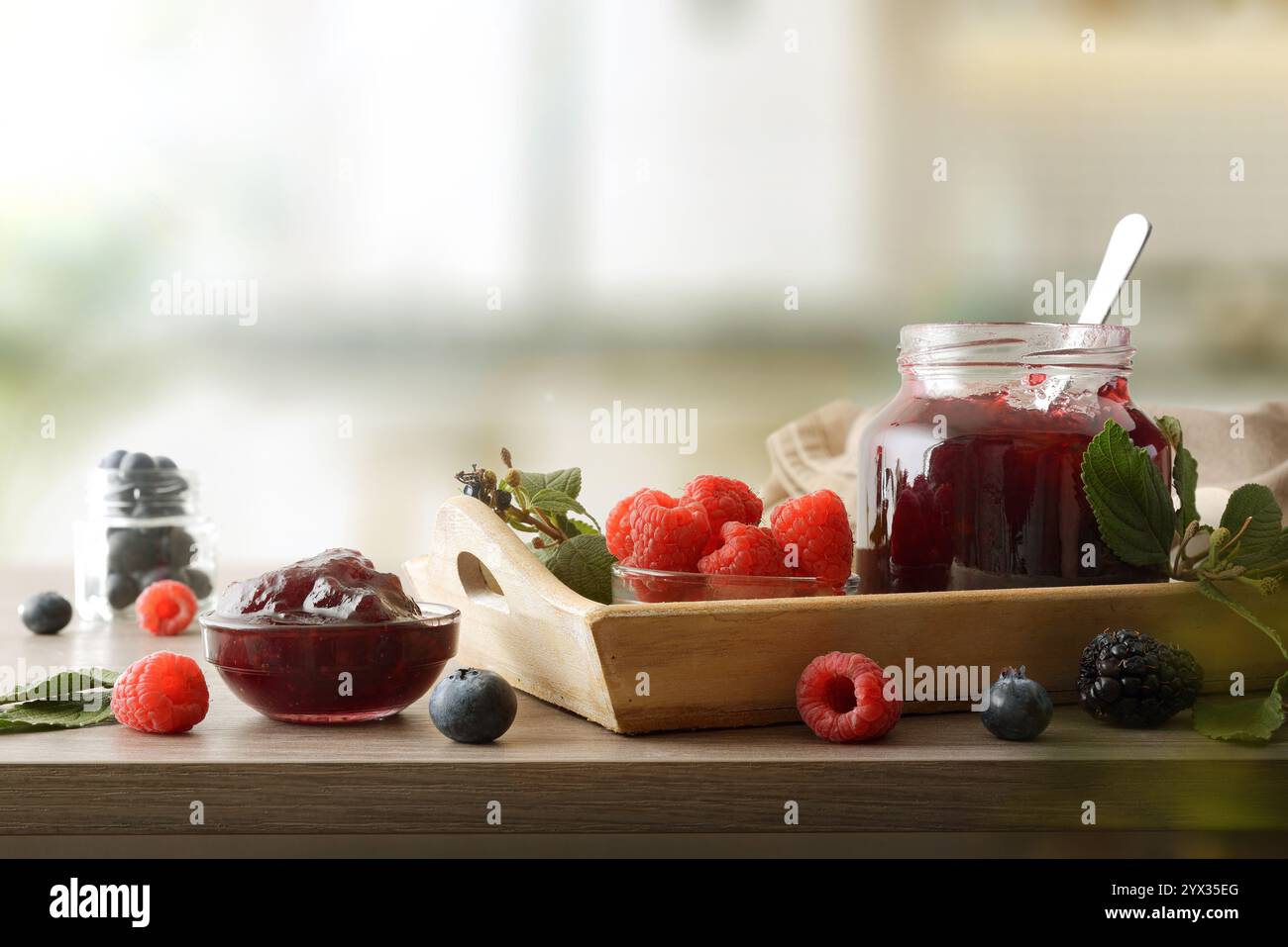 Forest fruit jam on a wooden tray on a table full of fruits with ...