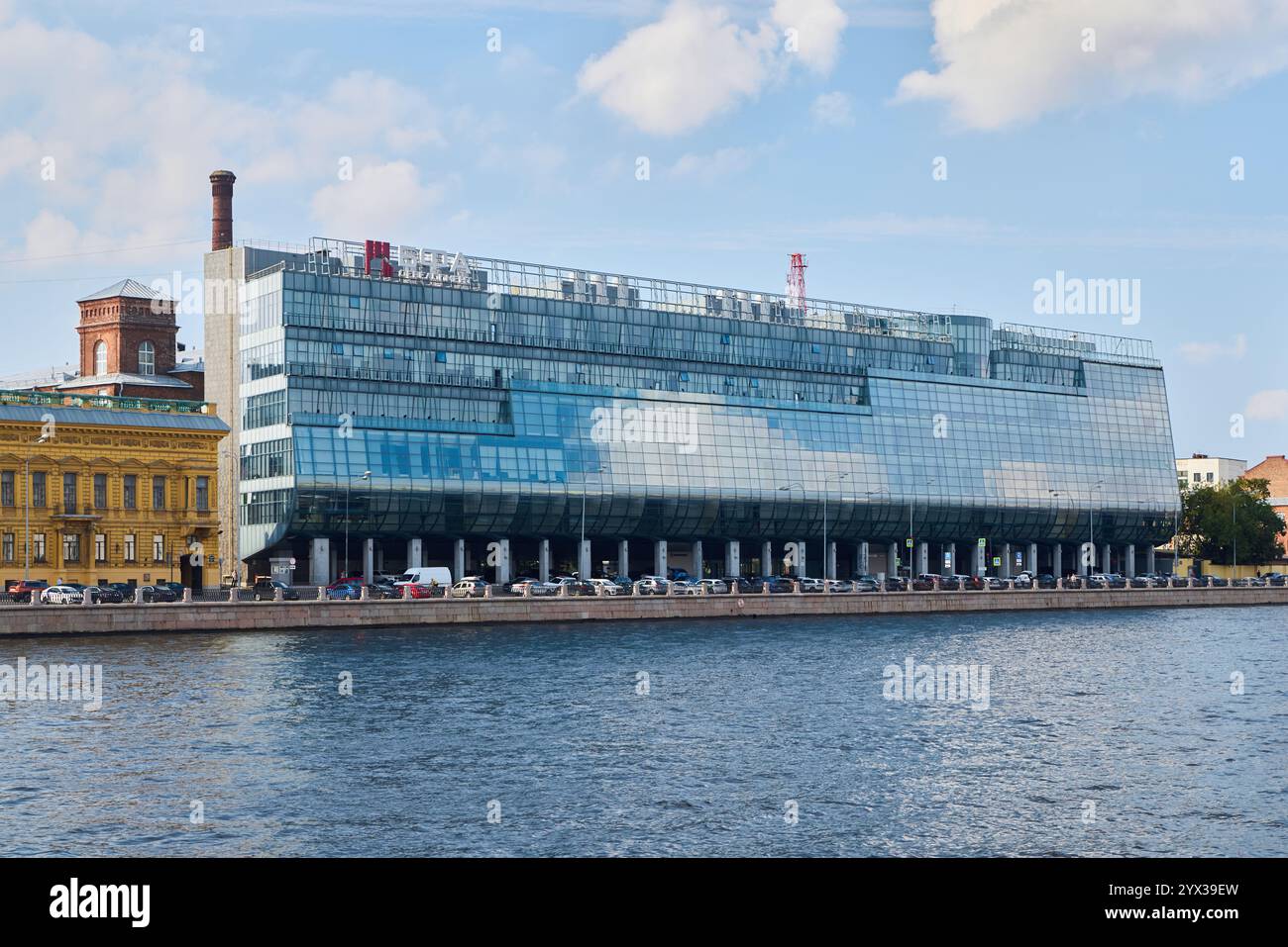 A stunning modern waterfront building featuring an elegant glass facade ...