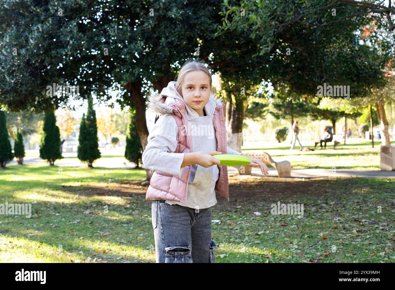 Throwing happy girl child playing flying disc in a sunny, green outdoor ...