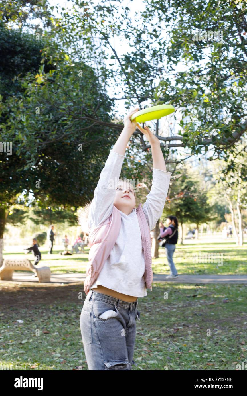 Playful child girl catching flying disc in park. Happiness and ...