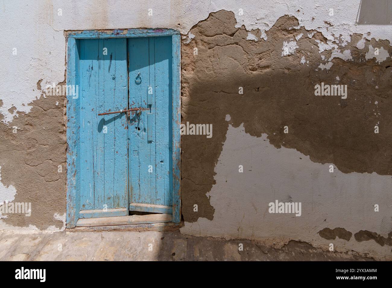Very old, dilapidated and crumbling building facade with old trees ...
