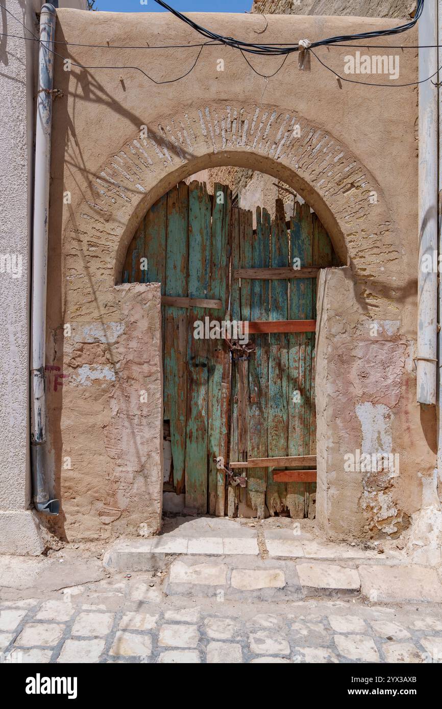 Very old, dilapidated and crumbling building facade with old trees ...