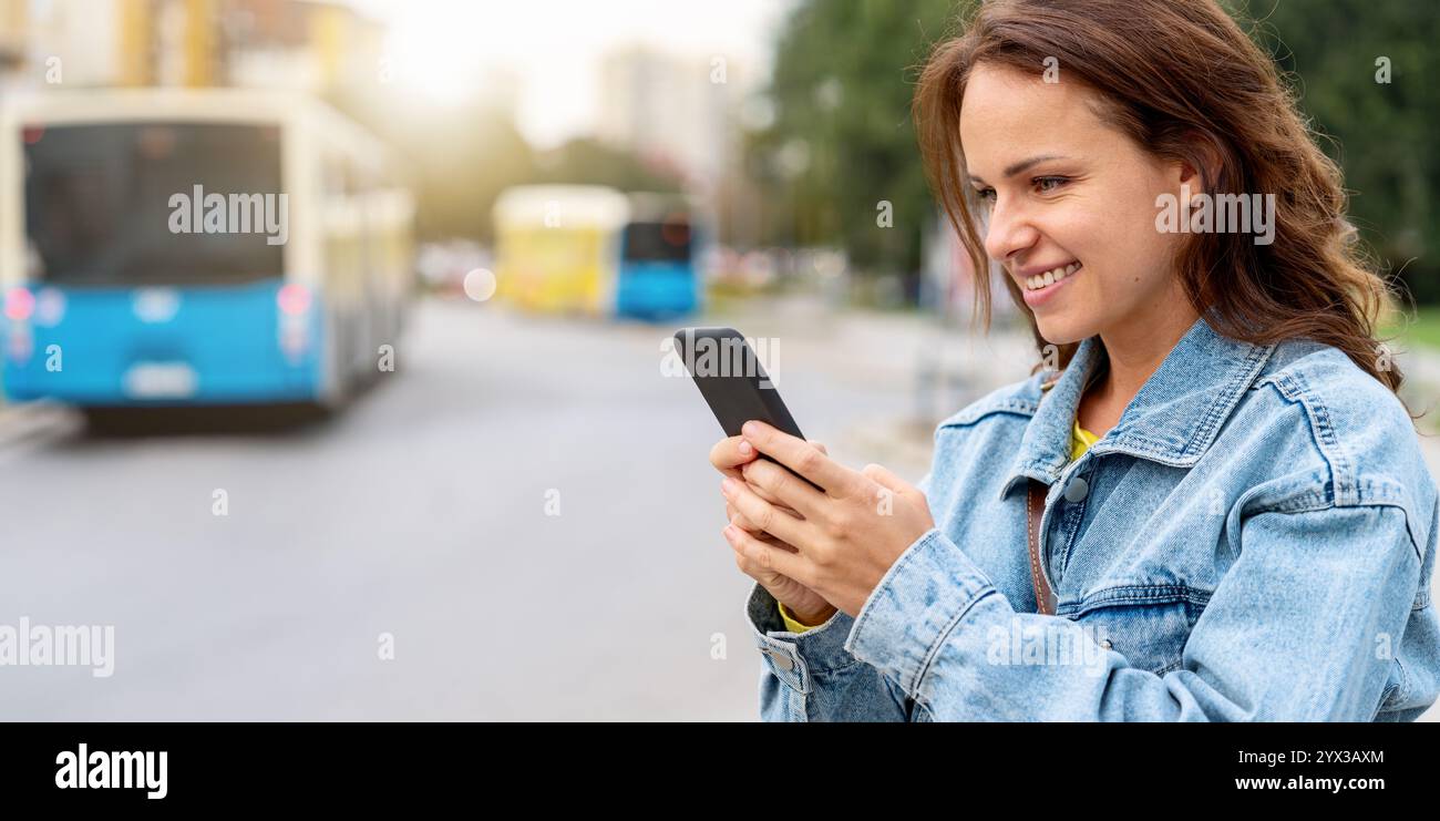 Urban young woman using smartphone on city street. Searching public ...