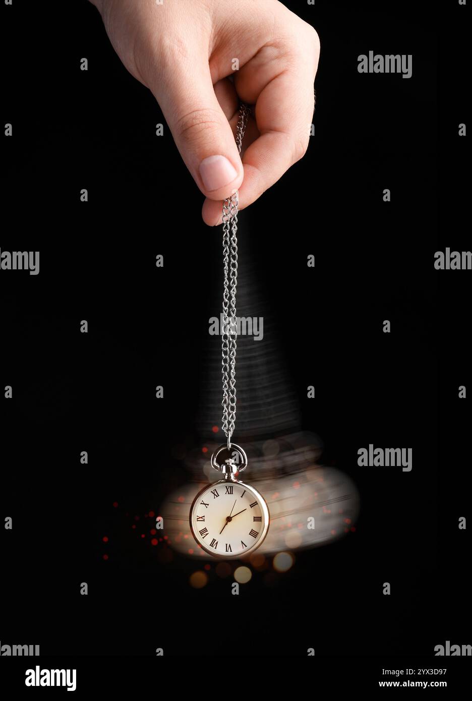 Hypnosis session. Woman swinging vintage pocket watch on black ...