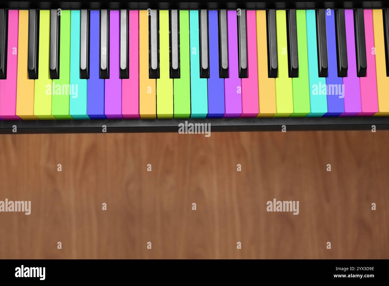 Piano with keys in colors of rainbow on floor, top view. Musical ...