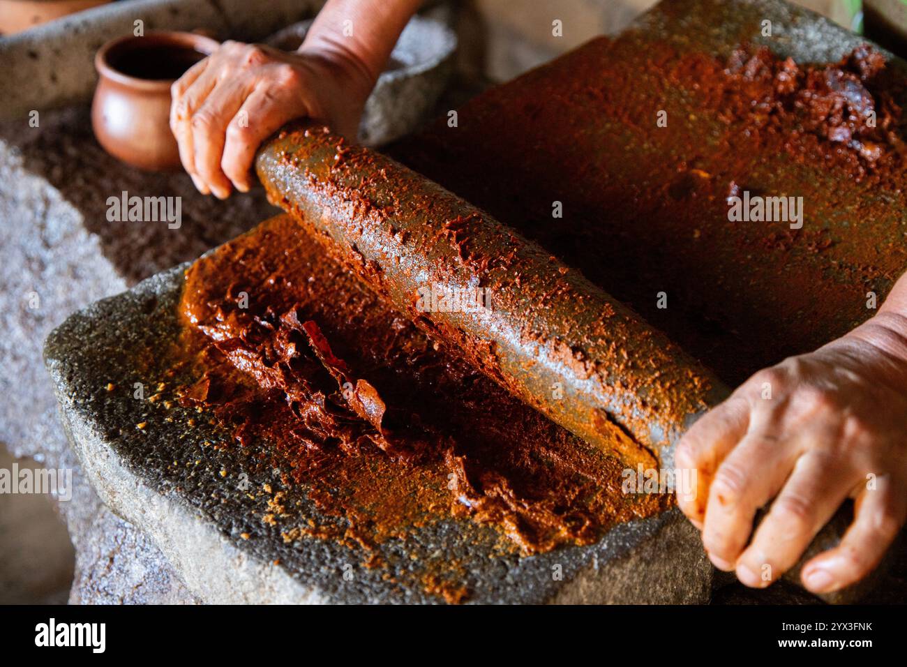 Woman from an indigenous community in Oaxaca preparing traditional red ...