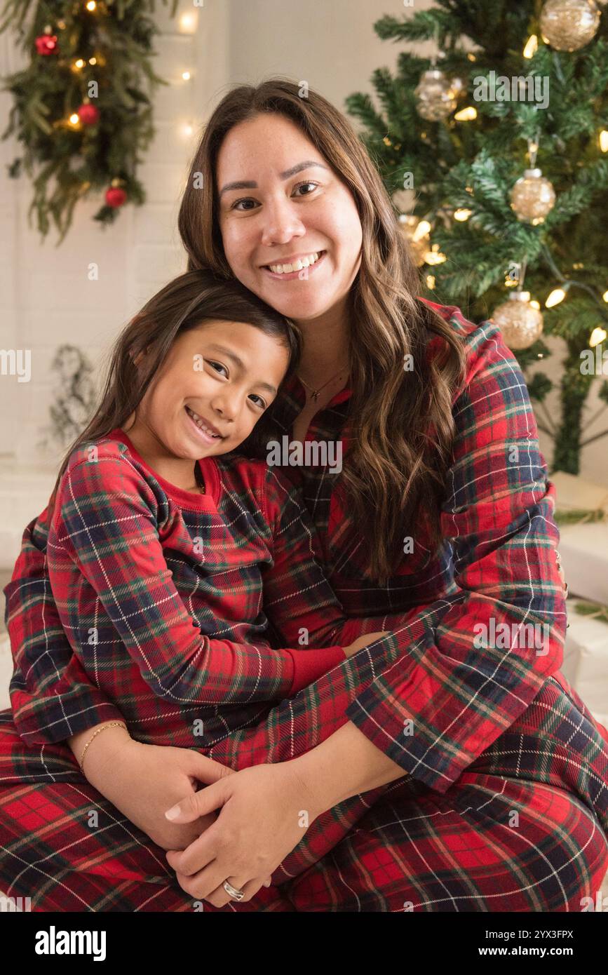 Daughter cuddling on moms lap Stock Photo - Alamy