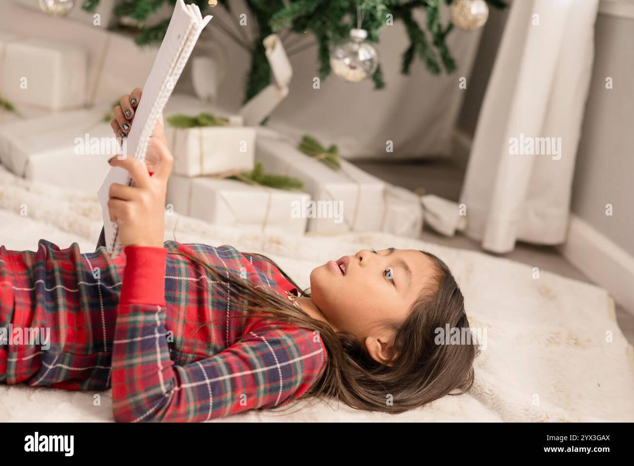 Girl reading letter from notebook laying on her back Stock Photo - Alamy
