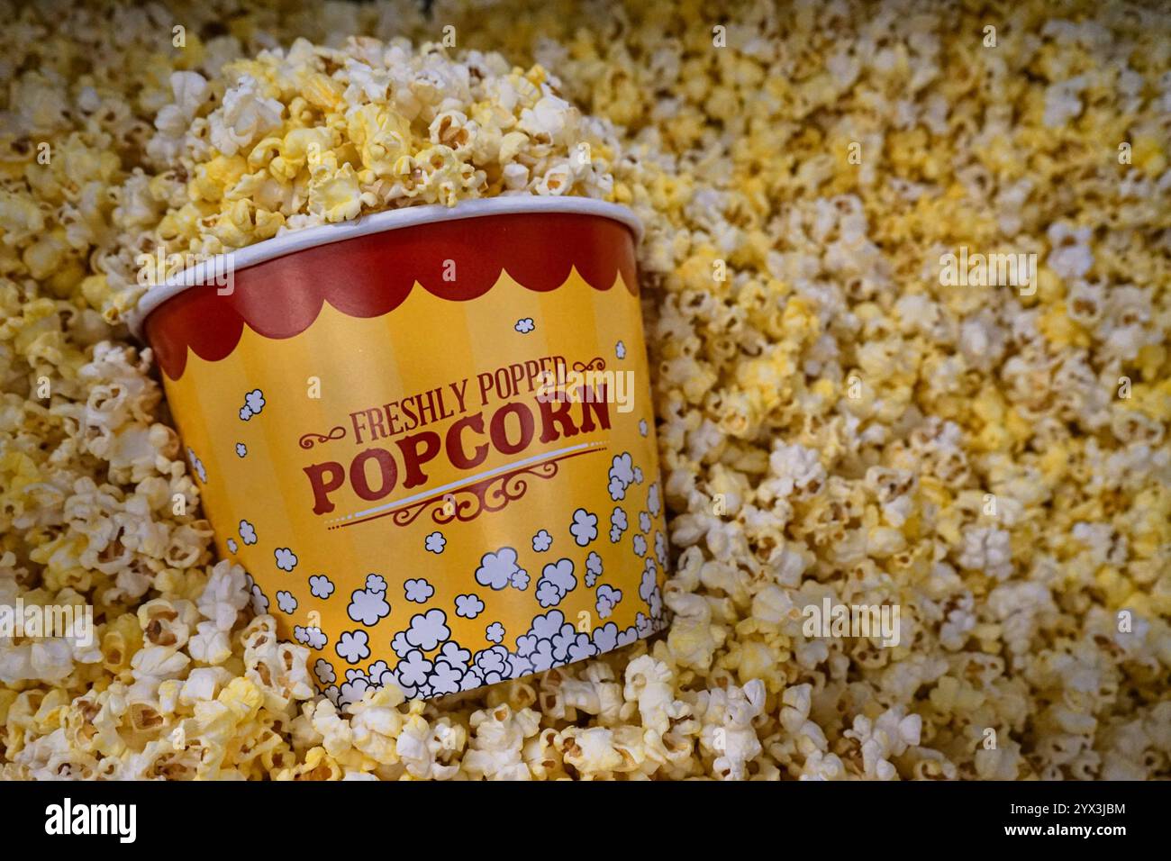 Overflowing Movie theater popcorn bucket Stock Photo - Alamy