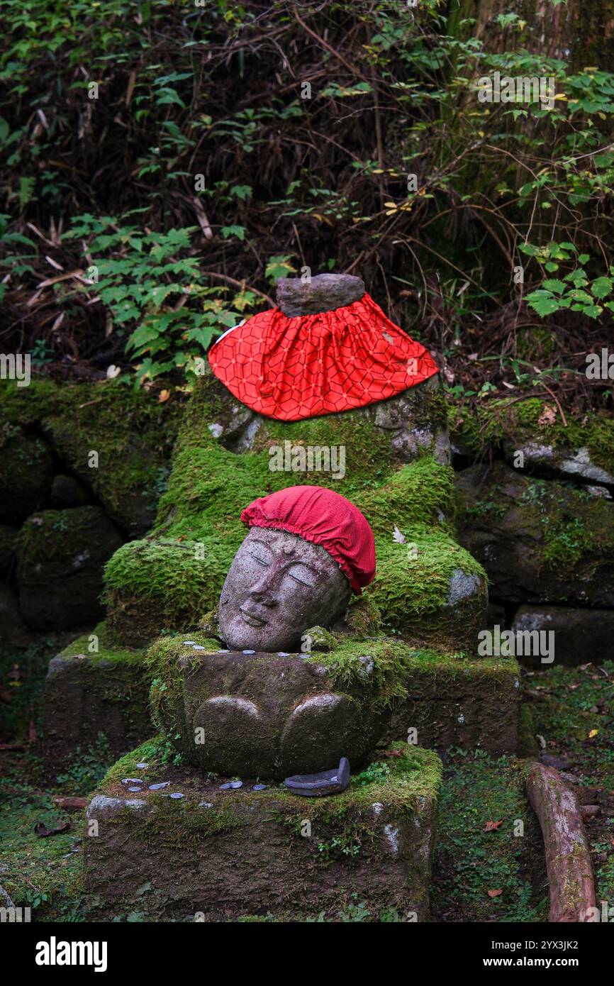 A headless buddha statue is overgrown with moss in Japan Stock Photo ...