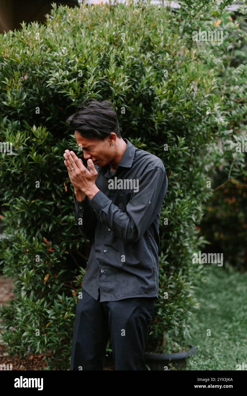 A Southeast Asian man sneezing, captured in a natural moment. Perfect ...