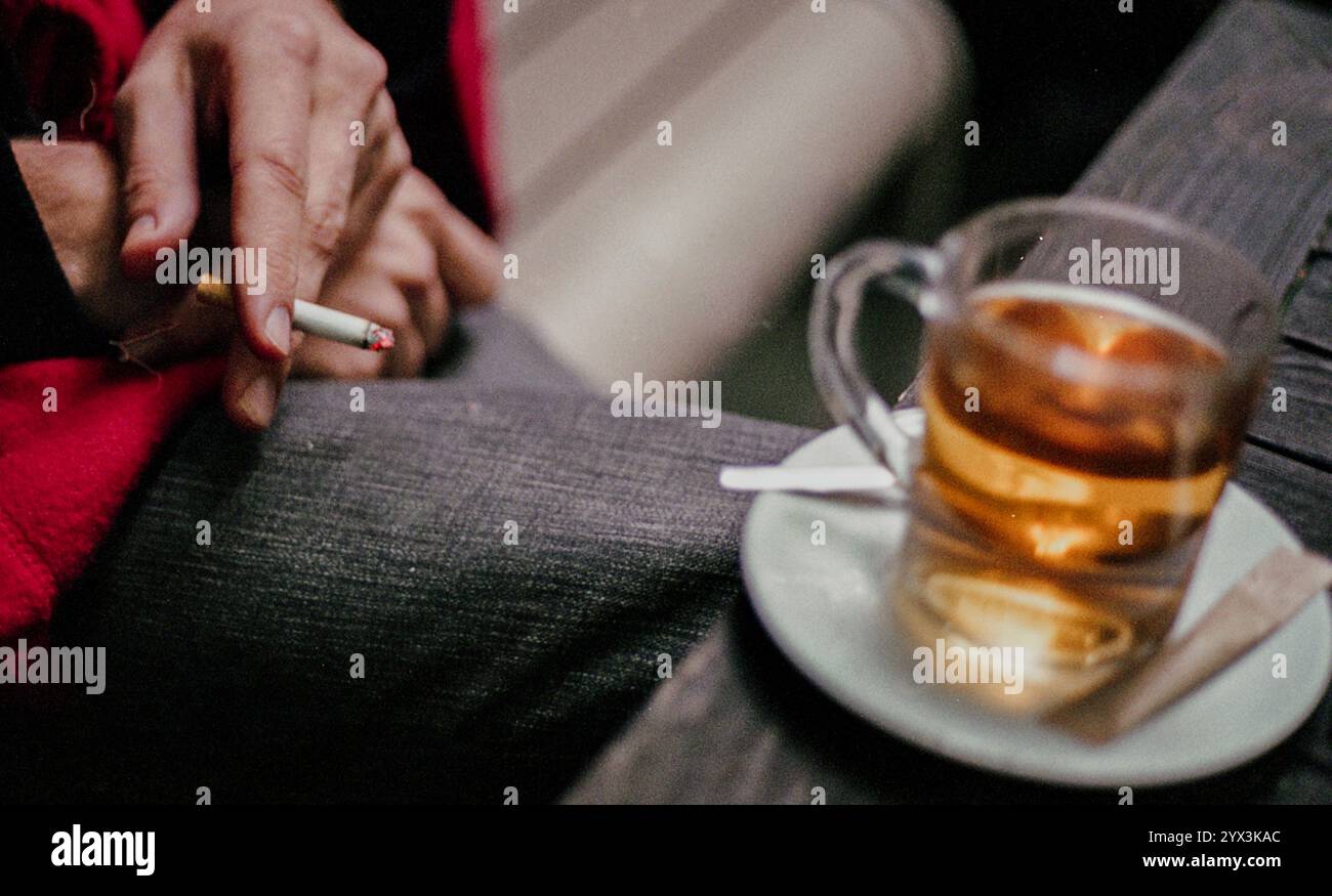 Man smoking a cigarette while drinking tea Stock Photo - Alamy