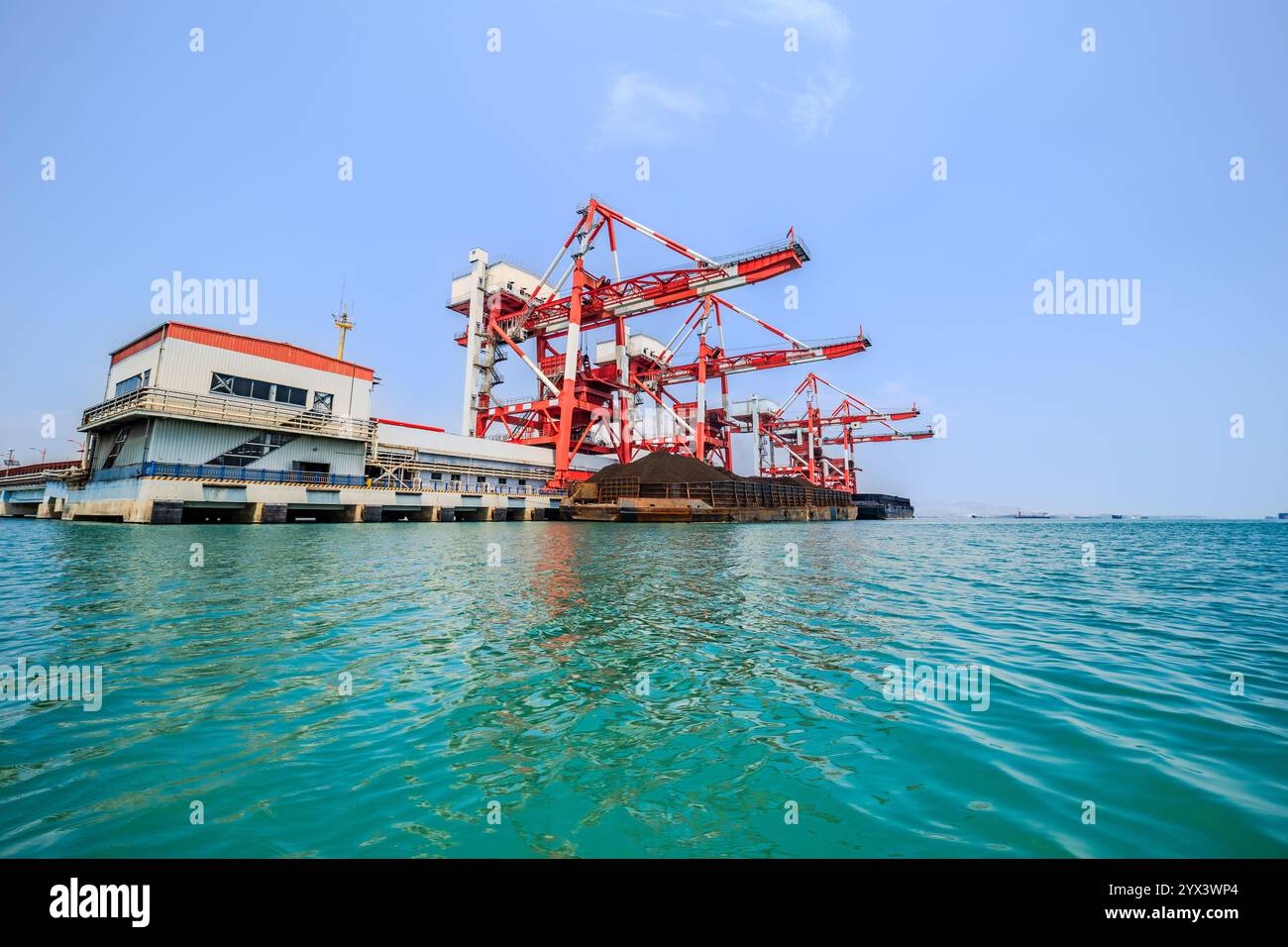 Industrial Crane Unloading Coal from a Barge for Power Plant Operations ...