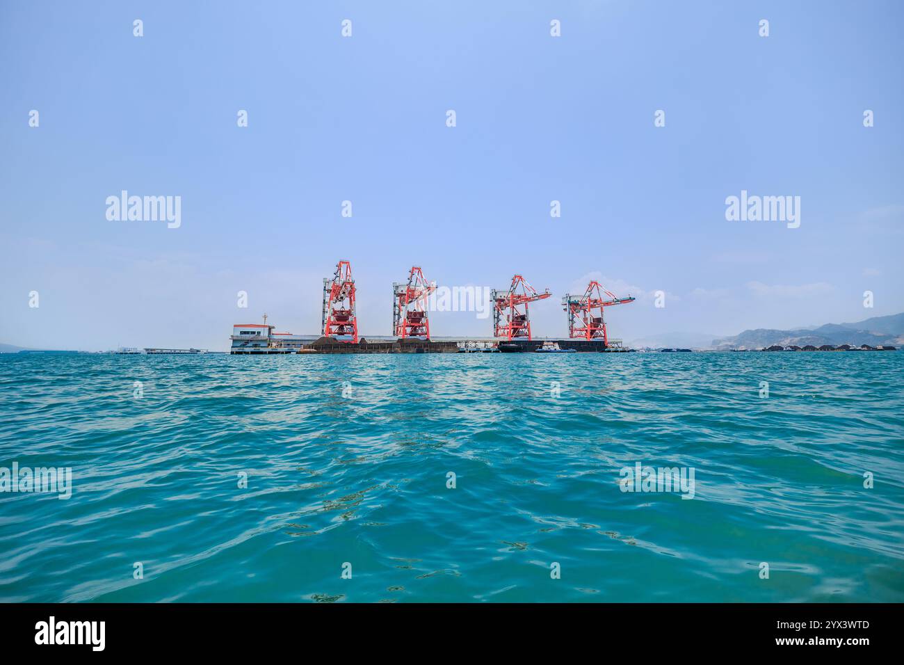 Industrial Crane Unloading Coal from a Barge for Power Plant Operations ...