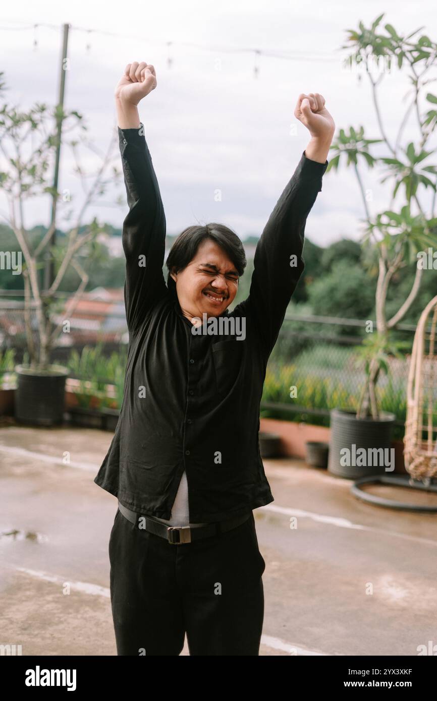 A Southeast Asian man stretching his body, resembling the movements ...