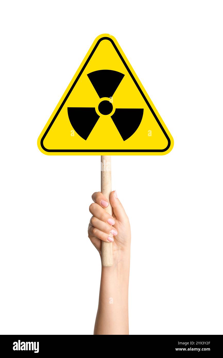 Radiation sign in a person’s hand on a blank background. Great for ...