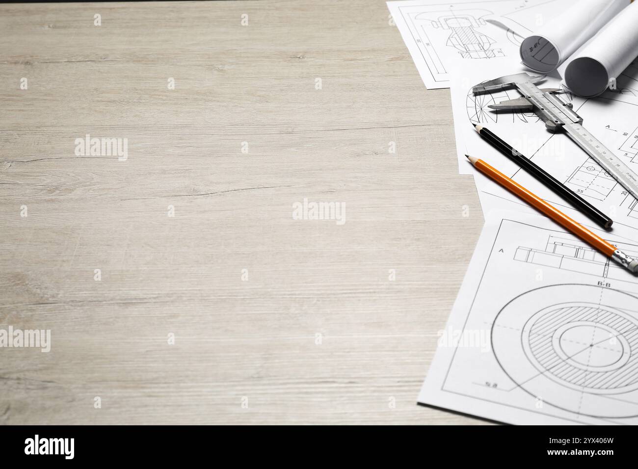 Different engineering drawings, vernier caliper and pencils on wooden ...