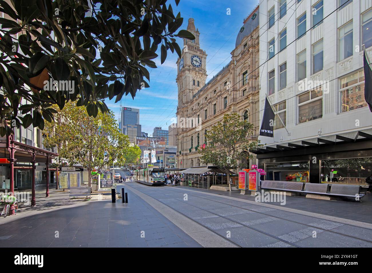 Busy Melbourne street scene with iconic tram and historic clock tower ...
