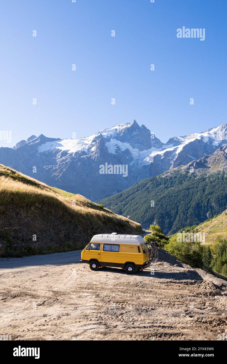Retro camper van parked in the forest with high mountains in the ...