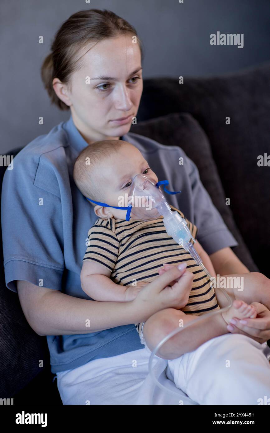 Mom giving nebulizer breathing treatment to sick infant baby at home ...