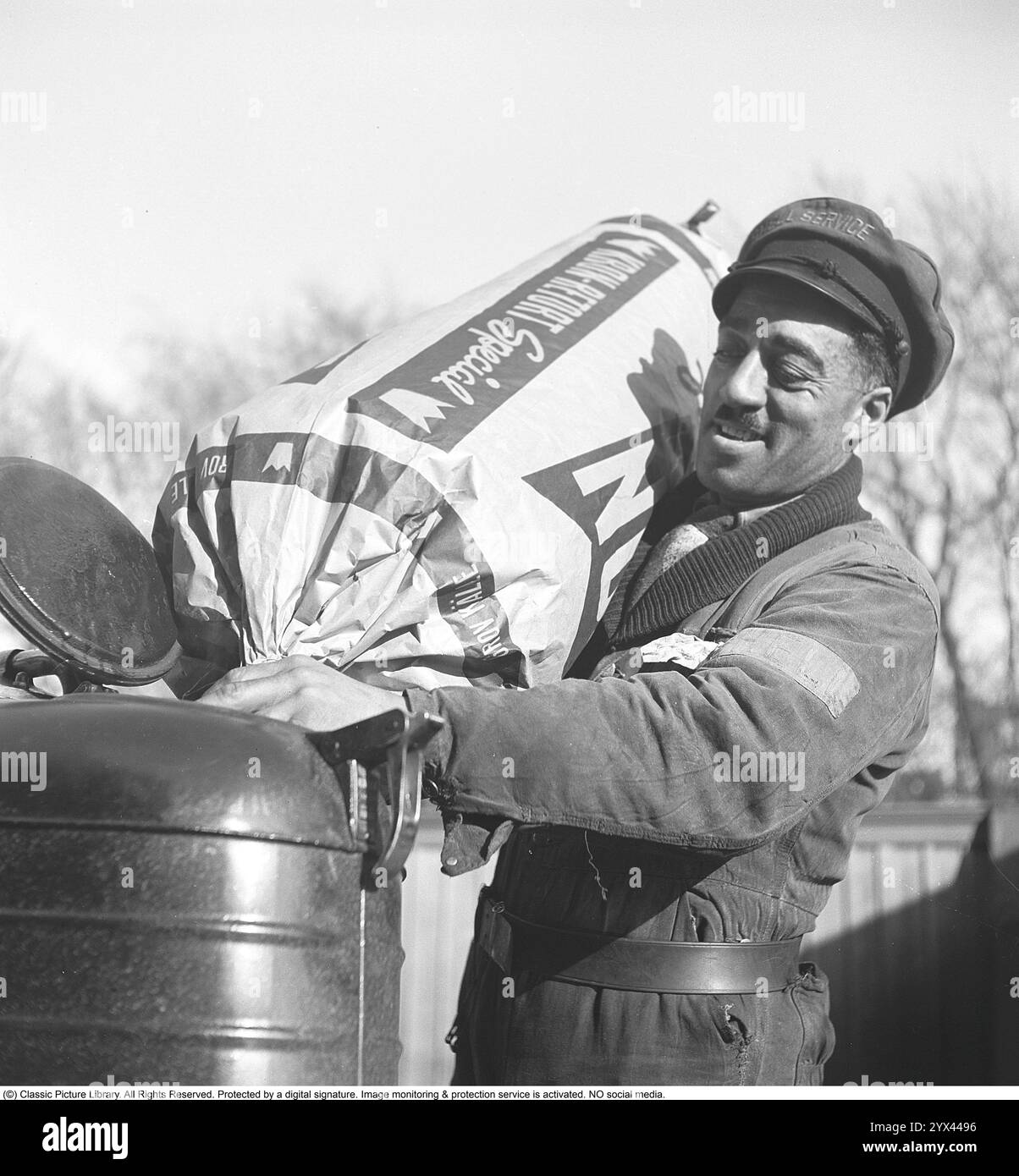 Wood gas 1945. A man at a Shell service station fills more coal into ...