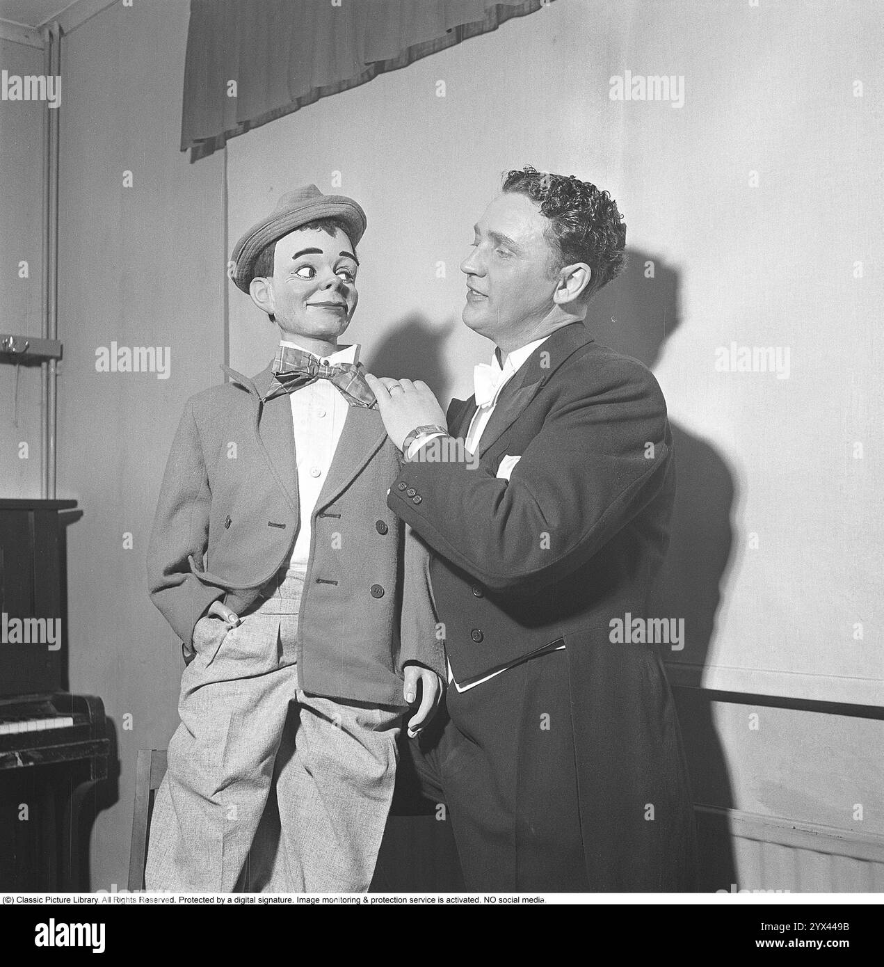 A ventriloquist with his dummy backstage before a performance, getting ...