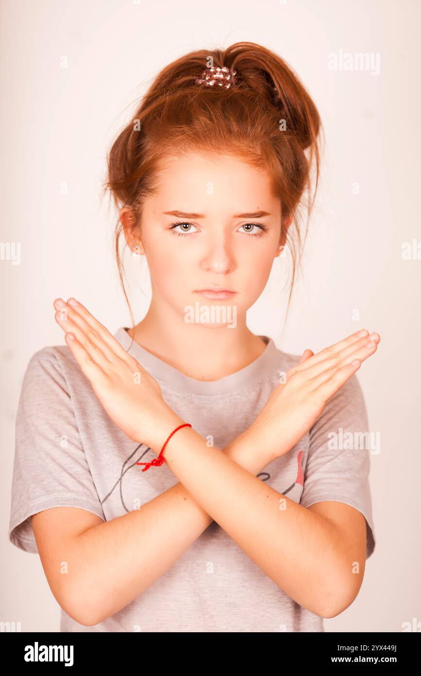 Happy beautiful girl smiling with closed eyes touching her red curly hair over white background ...