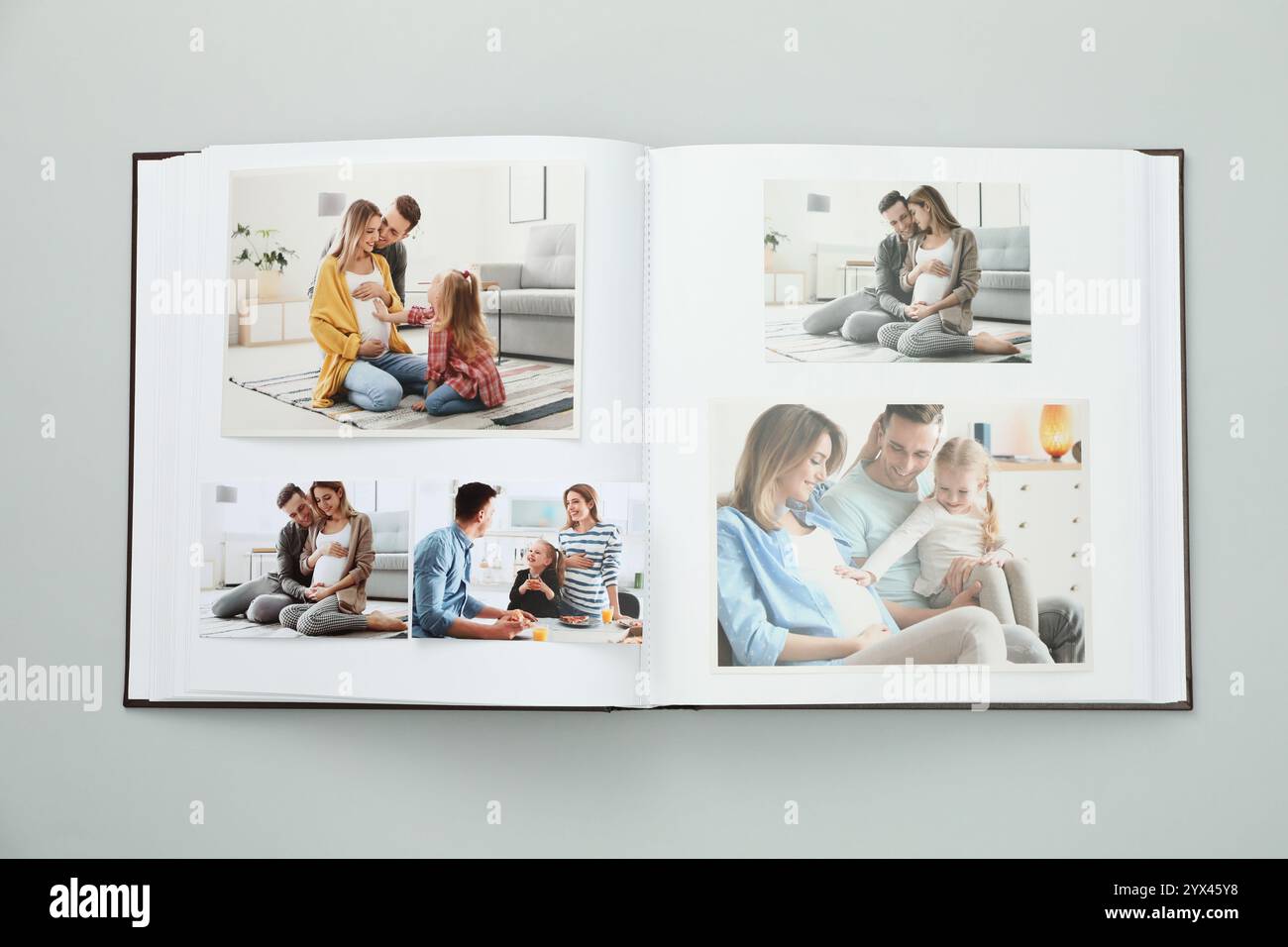 Open photo album with different photos on grey background, top view ...
