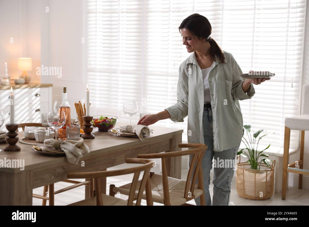 Woman setting table for dinner at home Stock Photo - Alamy