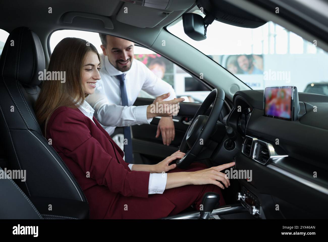 Happy salesman and client inside new car in salon Stock Photo - Alamy