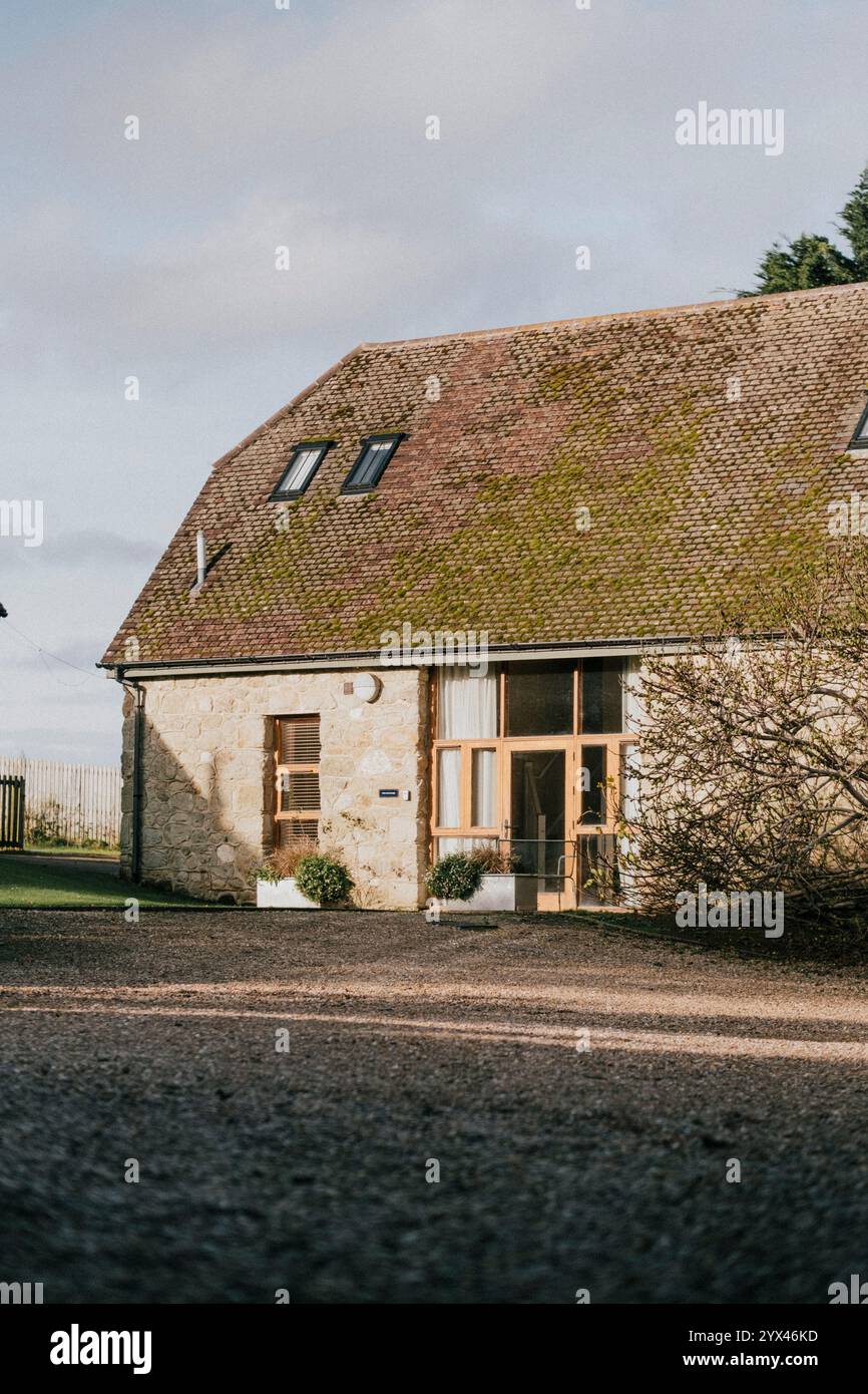 A small house with a slanted roof and a porch. The house is surrounded ...