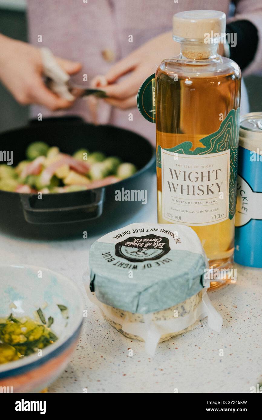 A bottle of whisky is placed next to a bowl of food on a counter. The ...