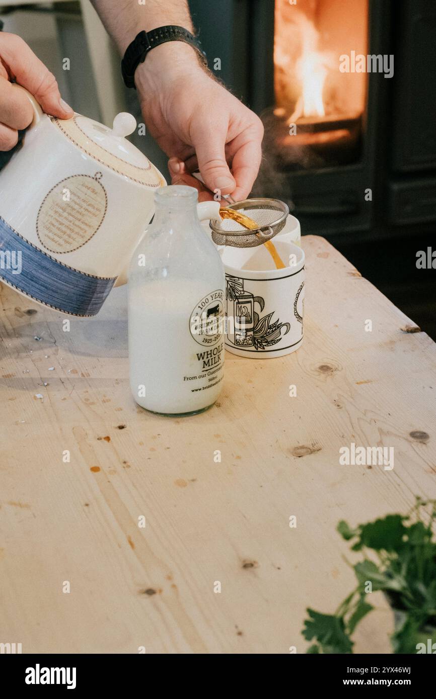 A man is pouring milk into a jar. The jar is labeled "Wheat Hill." The ...