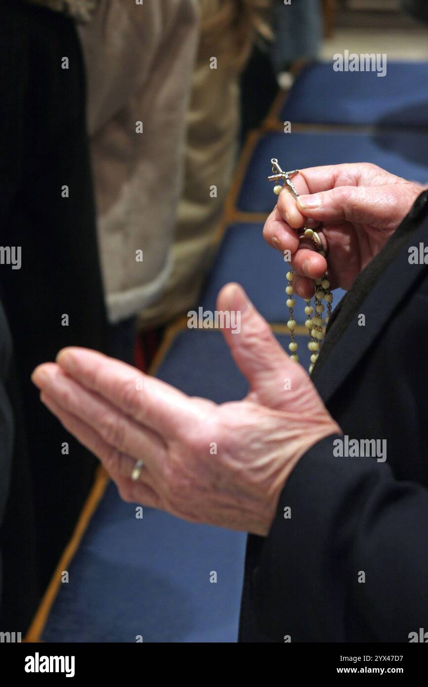 Elderly hands praying with Rosary Beads Stock Photo - Alamy