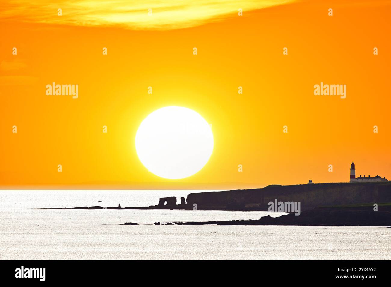 Souter Lighthouse and Marsden rock NT sillouhetted against a red sunset ...