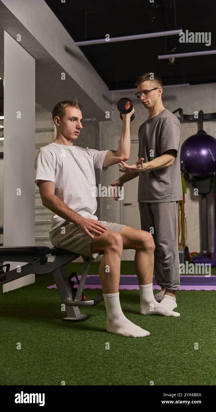 Man sitting and lifting dumbbell, focusing on arm recovery and strength ...