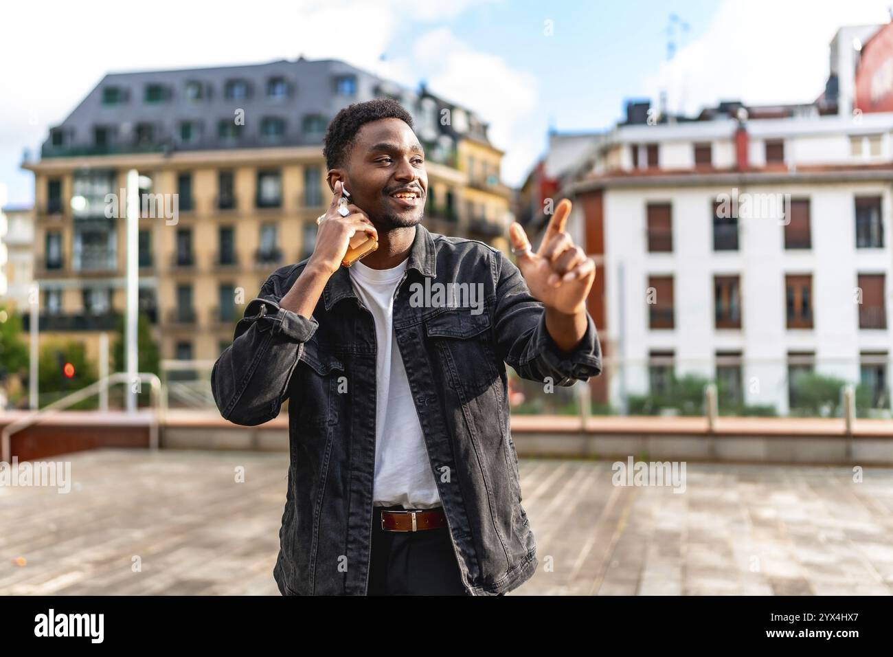 Cool african man dancing listening to music with earbuds in the city ...
