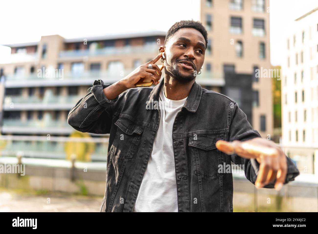 African cool man listening to music with earbuds and dancing in the ...