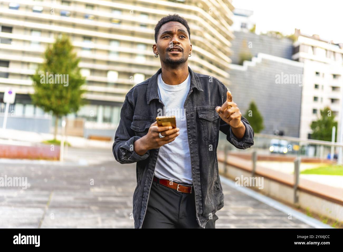 African man walking along the city using gps app to find a direction ...