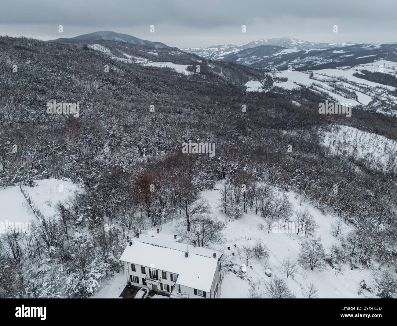 Aerial view of a snowy landscape featuring a white house nestled among ...
