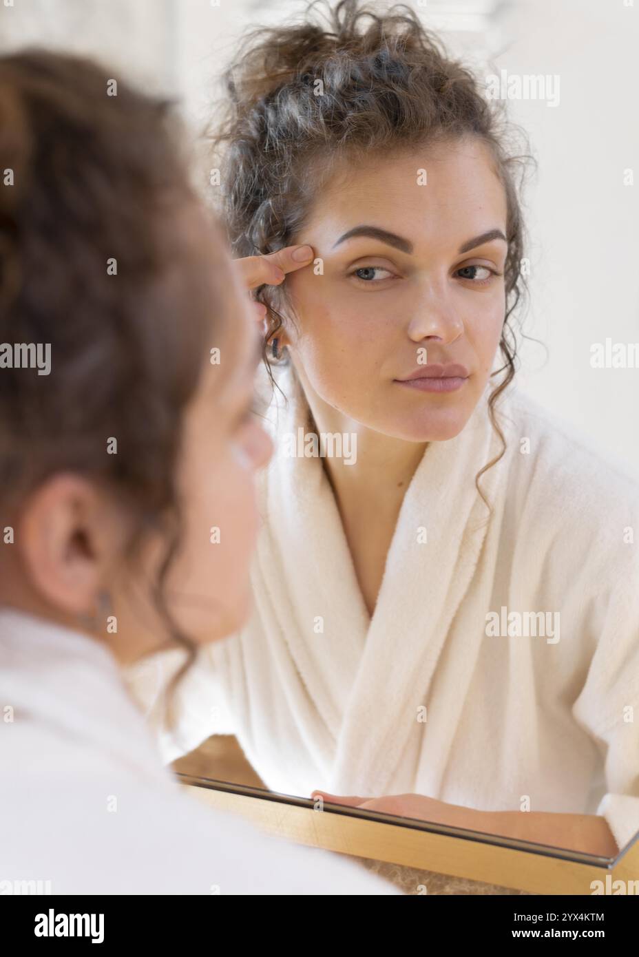 Woman looking mirror doing beauty face routine Stock Photo - Alamy
