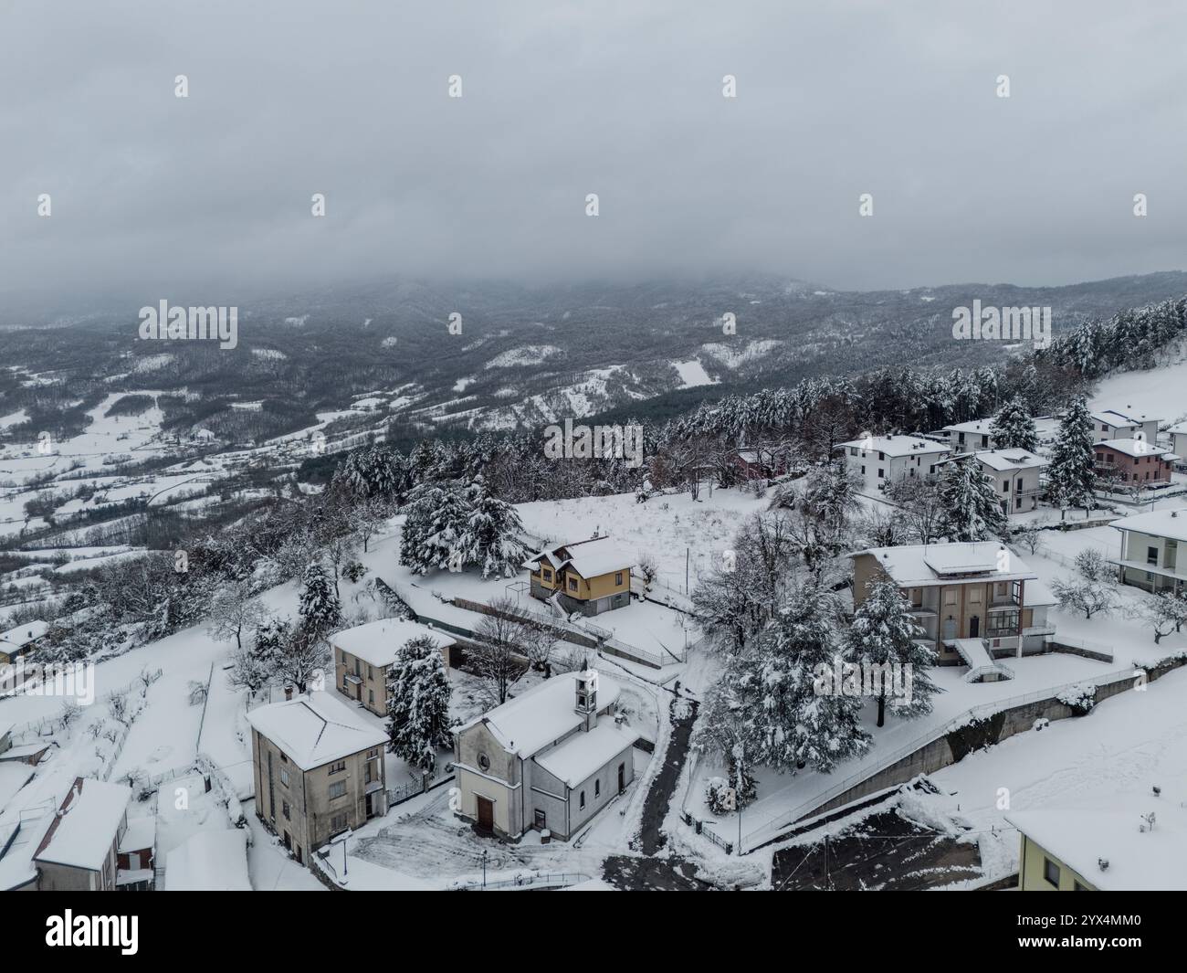 Aerial view of snow-covered houses and trees in bore, a small village ...