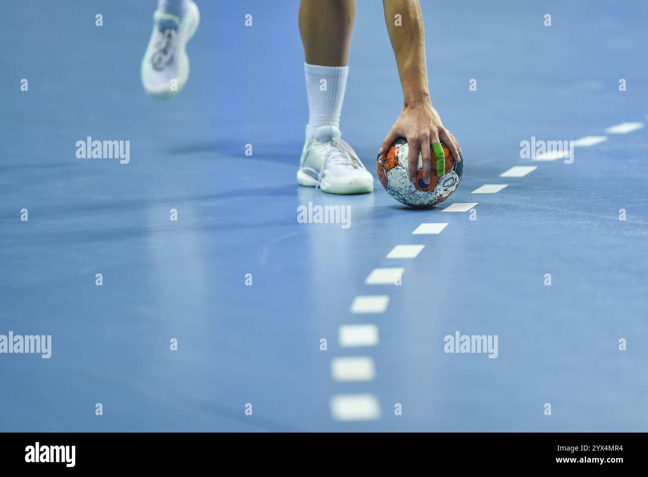 Handball - women's hand taking a ball laying on the 9 meters dotted ...