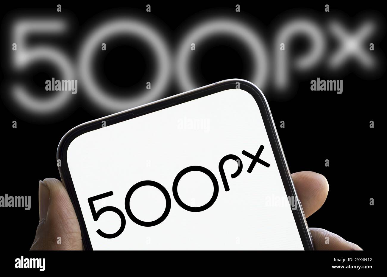 500px logo is displayed on smartphone.500px is a global online photo ...