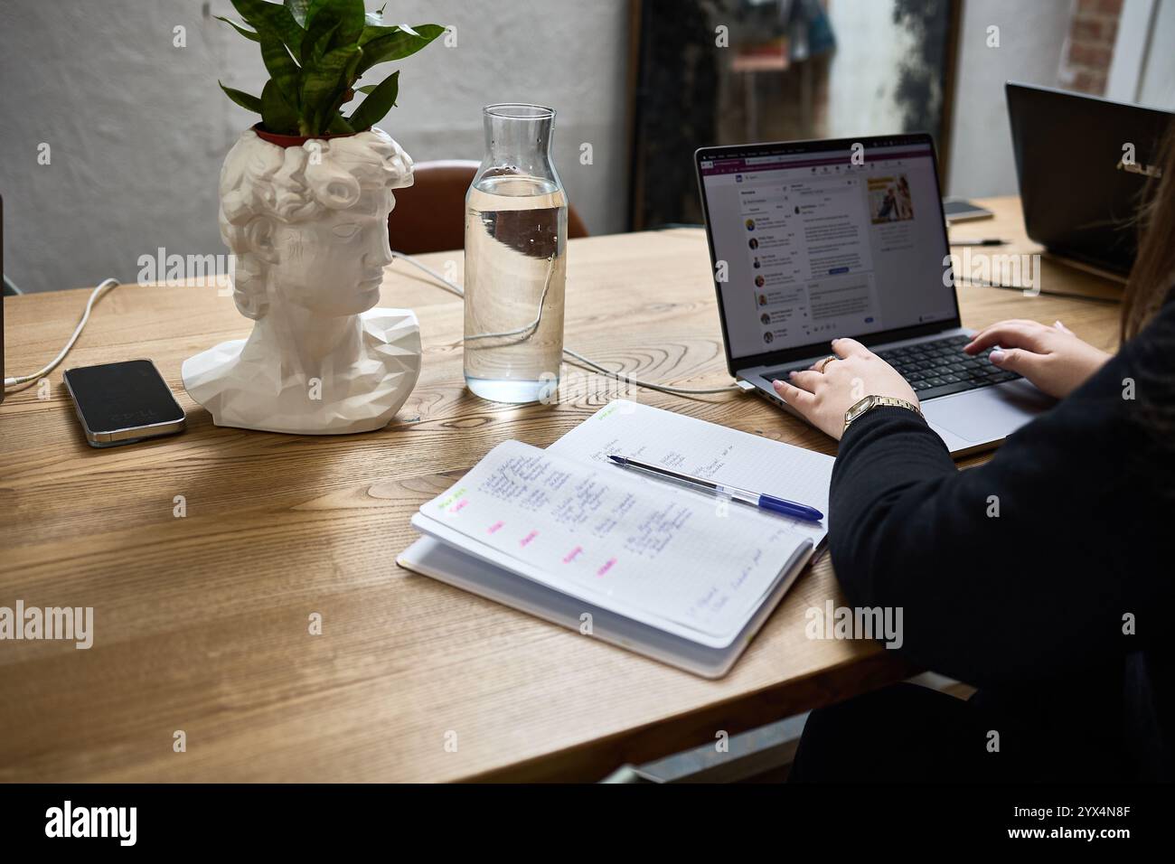 Modern office environment with laptop, note-taking, bust planter on a ...