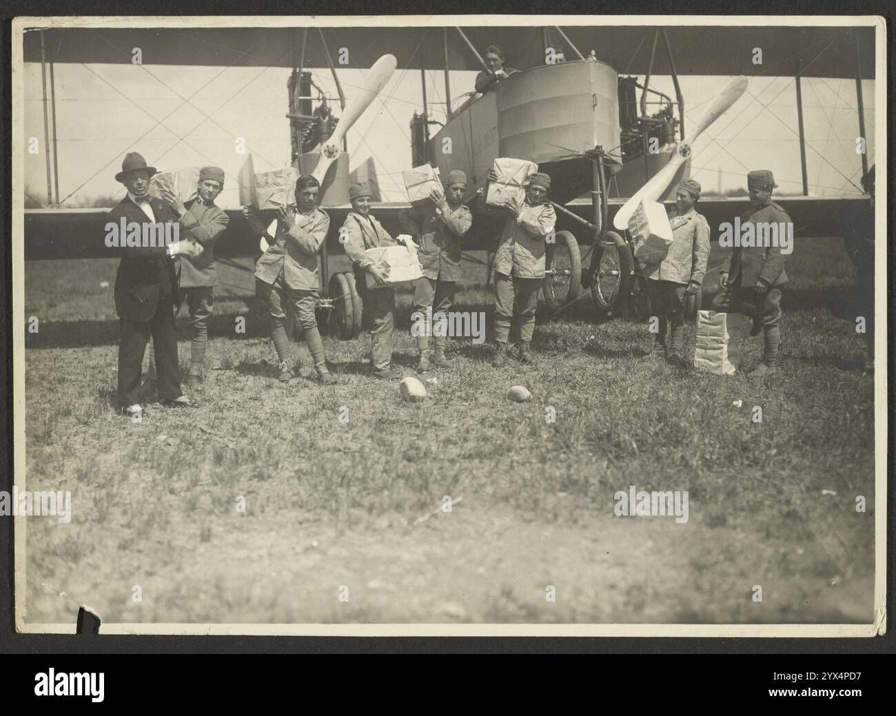 People loading supplies on airplane, 1919-1930. Group portrait of ...