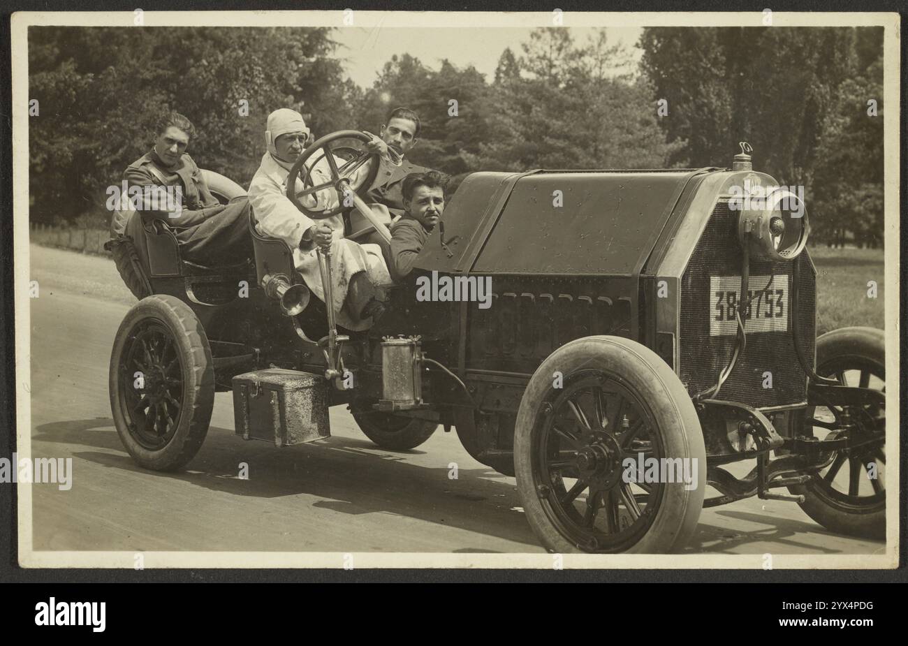 Group portrait in car, 1915-1925. Group portrait of men in a racecar. The driver is wearing an ...